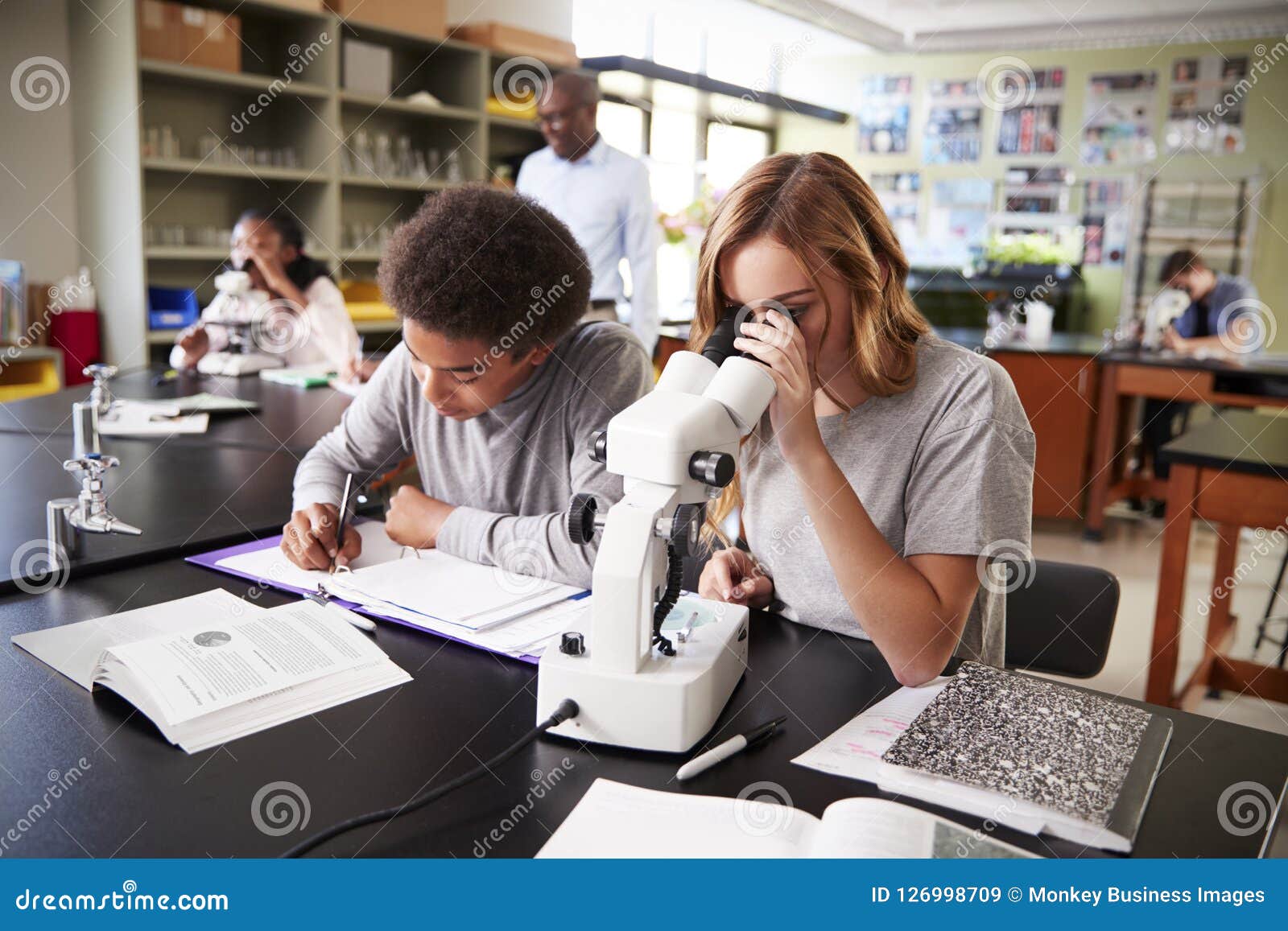 High School Students Looking through Microscope in Biology Class Stock ...
