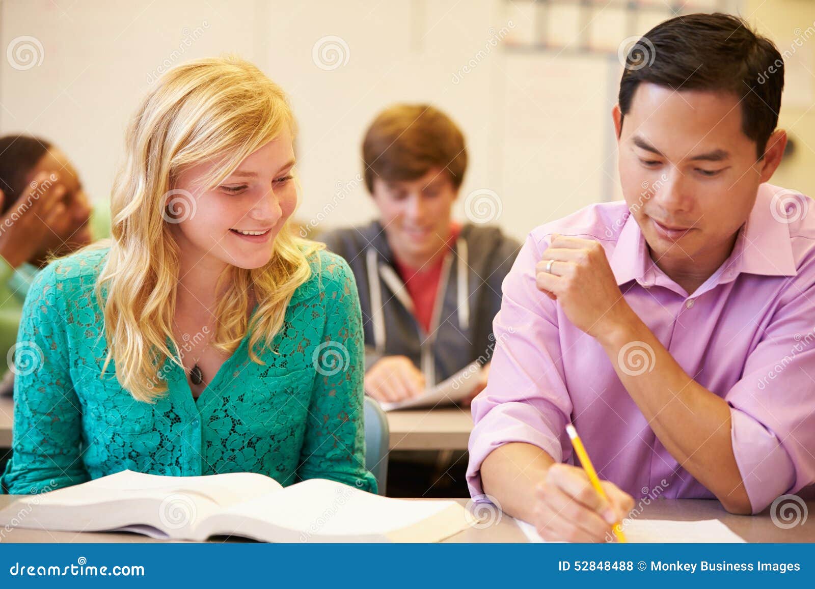 High School Teacher Helping Student with Written Work Stock Photo ...