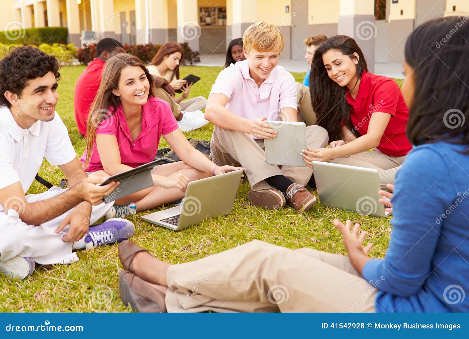 High School Teacher Sitting Outdoors with Students on Campus Stock ...
