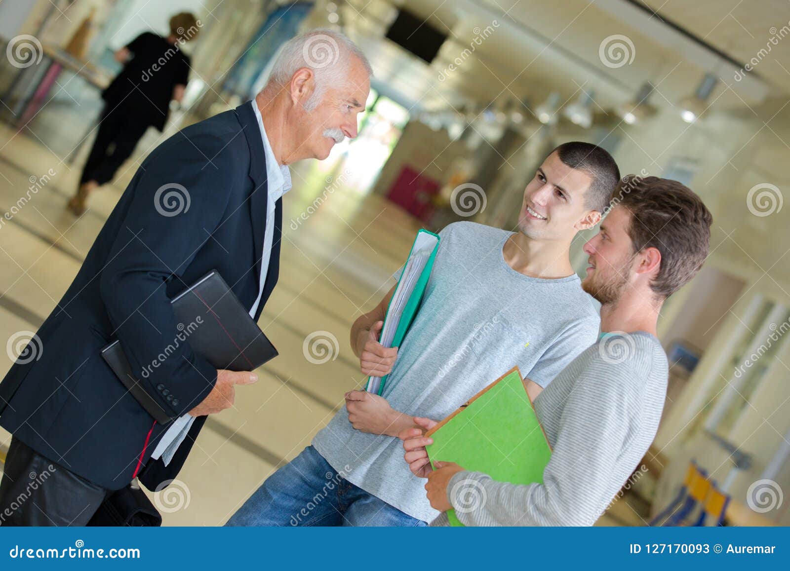 High School Teacher Talking To Students in Corridor Stock Image - Image ...