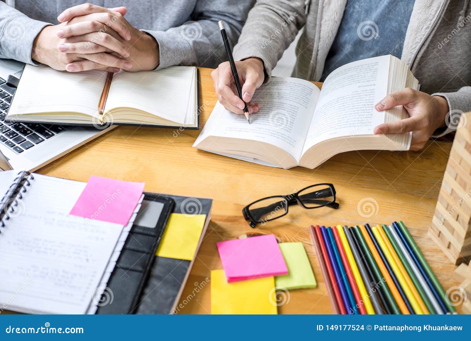 High School Tutor or College Student Group Sitting at Desk in Library ...