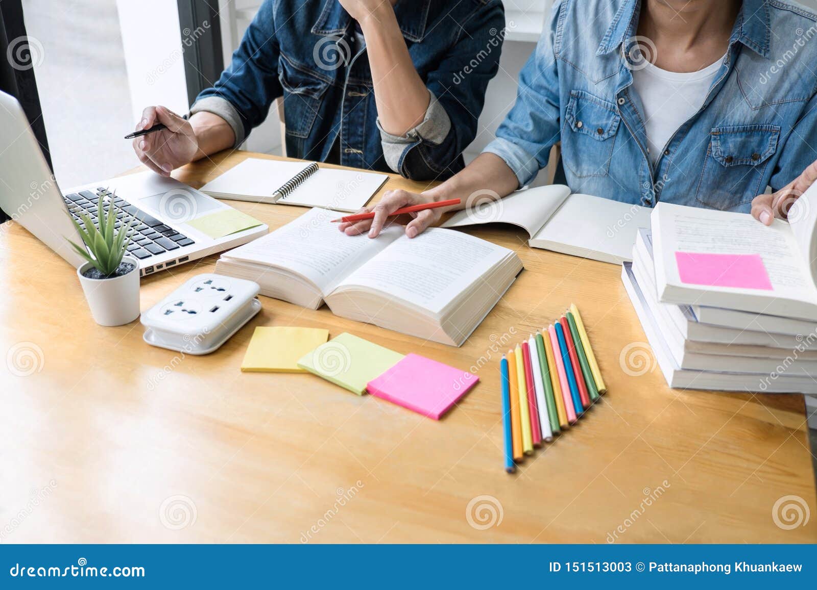 High School Tutor or College Student Group Sitting at Desk in Library ...