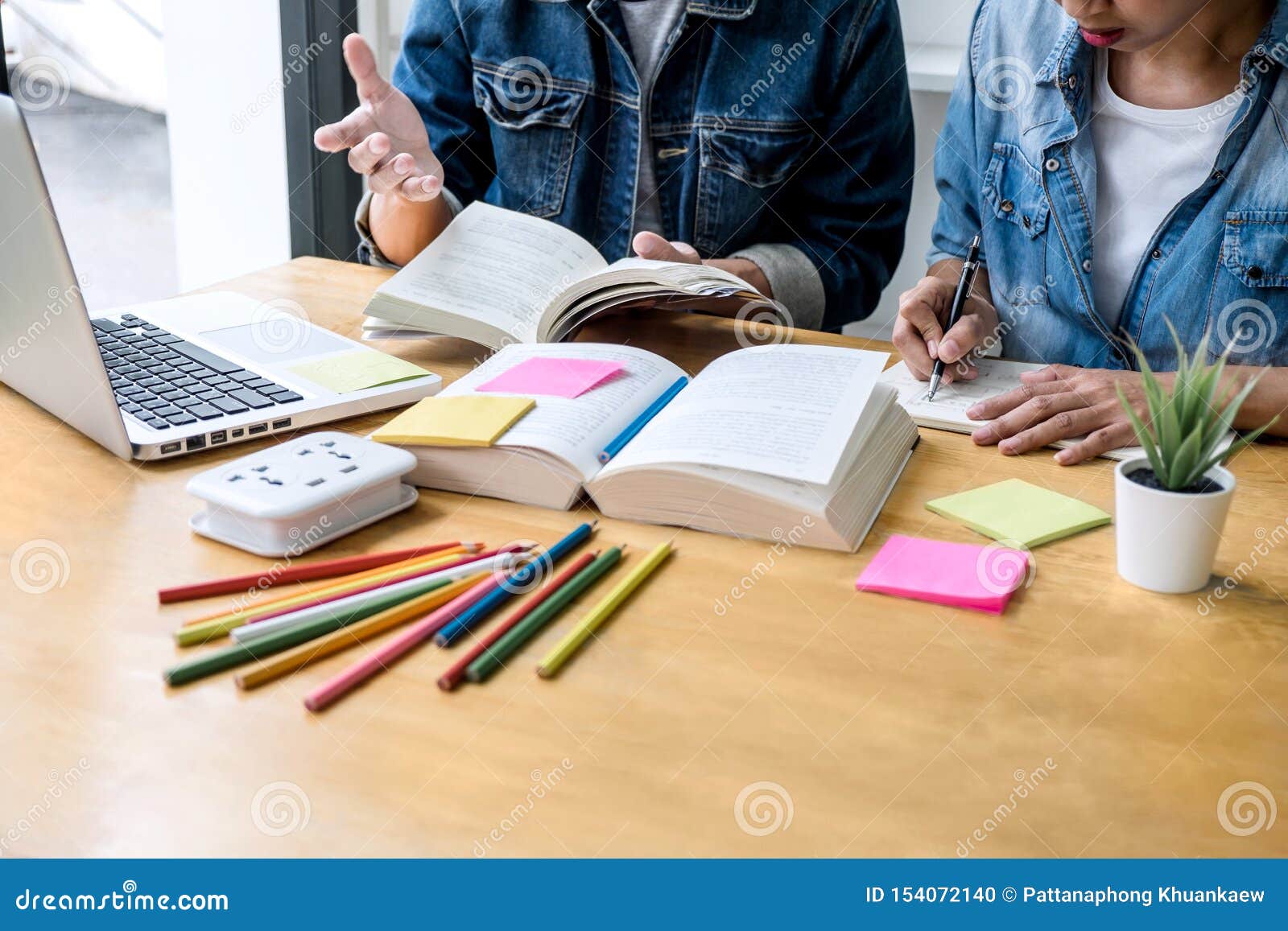 High School Tutor or College Student Group Sitting at Desk in Library ...
