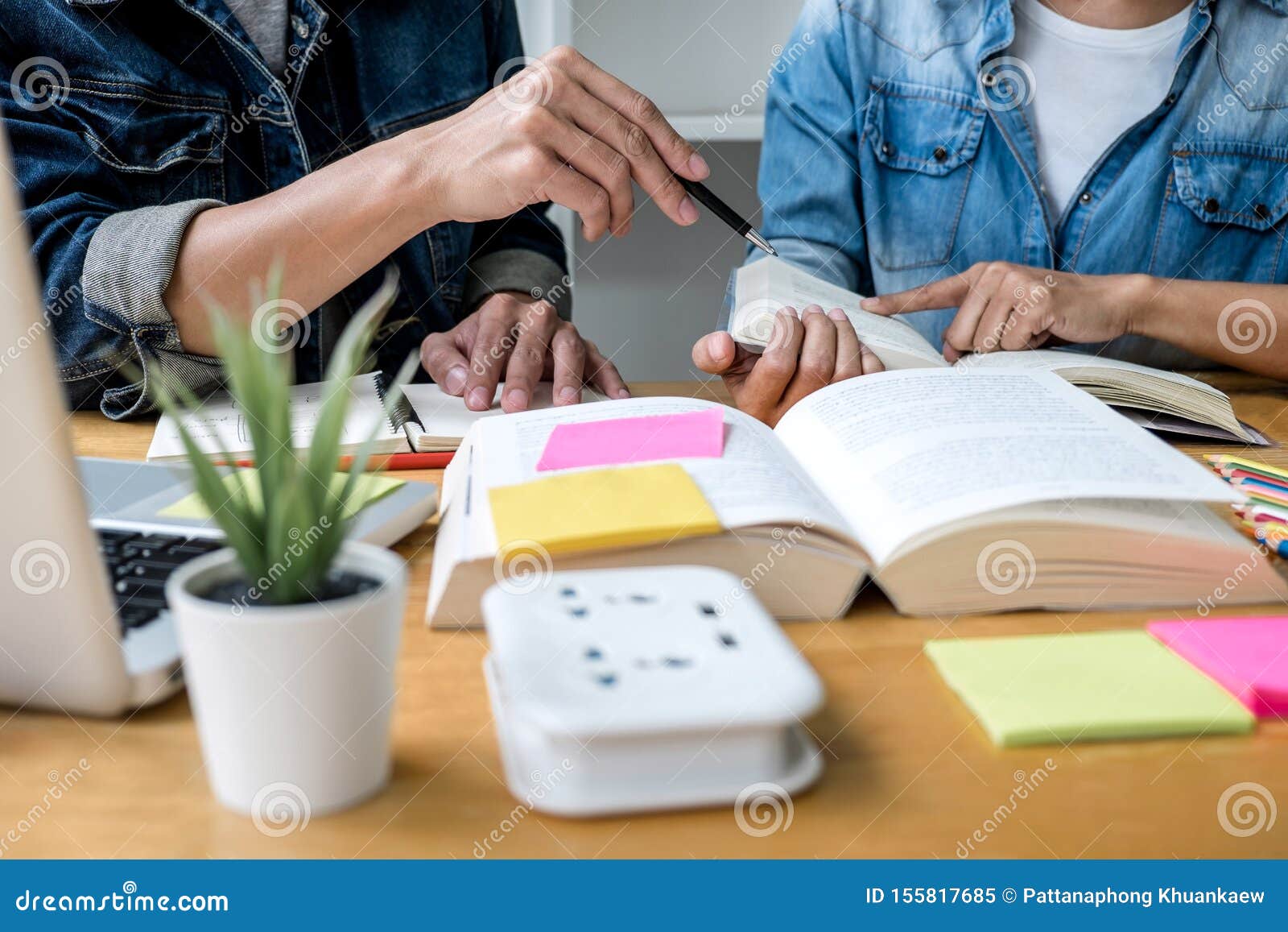 High School Tutor or College Student Group Sitting at Desk in Library ...