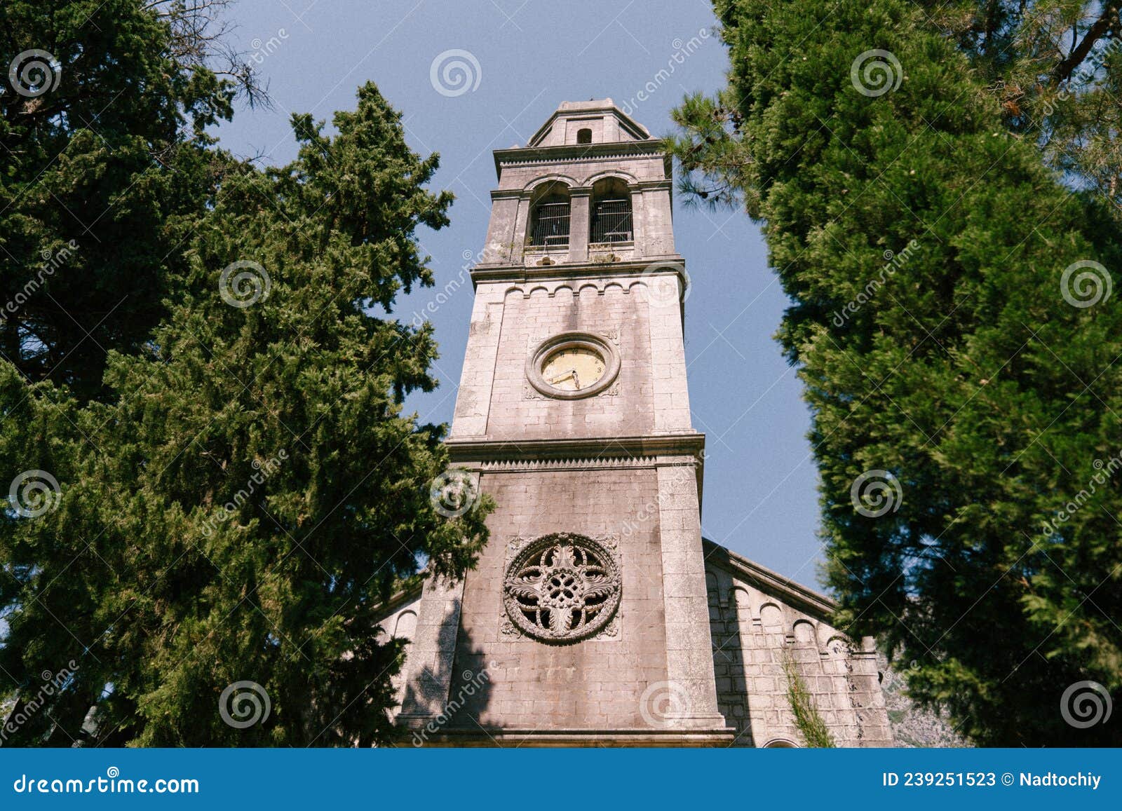 High Stone Bell Tower with a Clock among the Trees Stock Image - Image ...