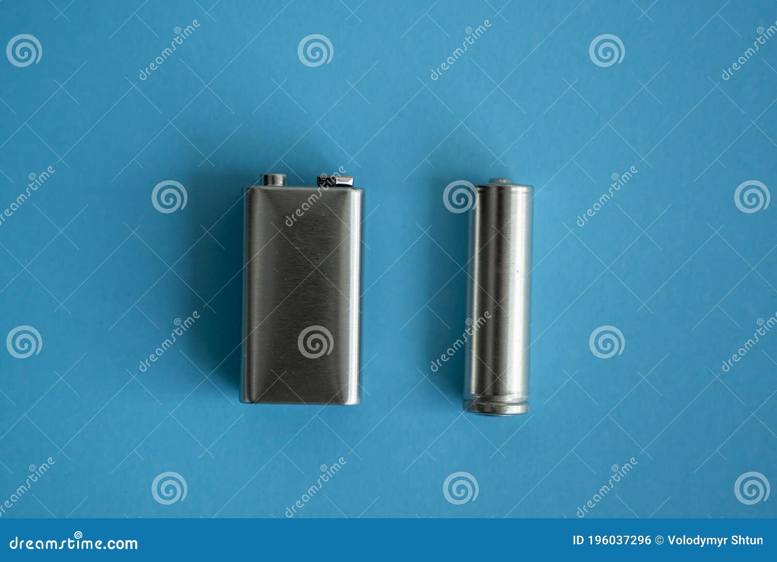 High Voltage Volt 9V Battery and Alkaline AA Battery on a Blue ...