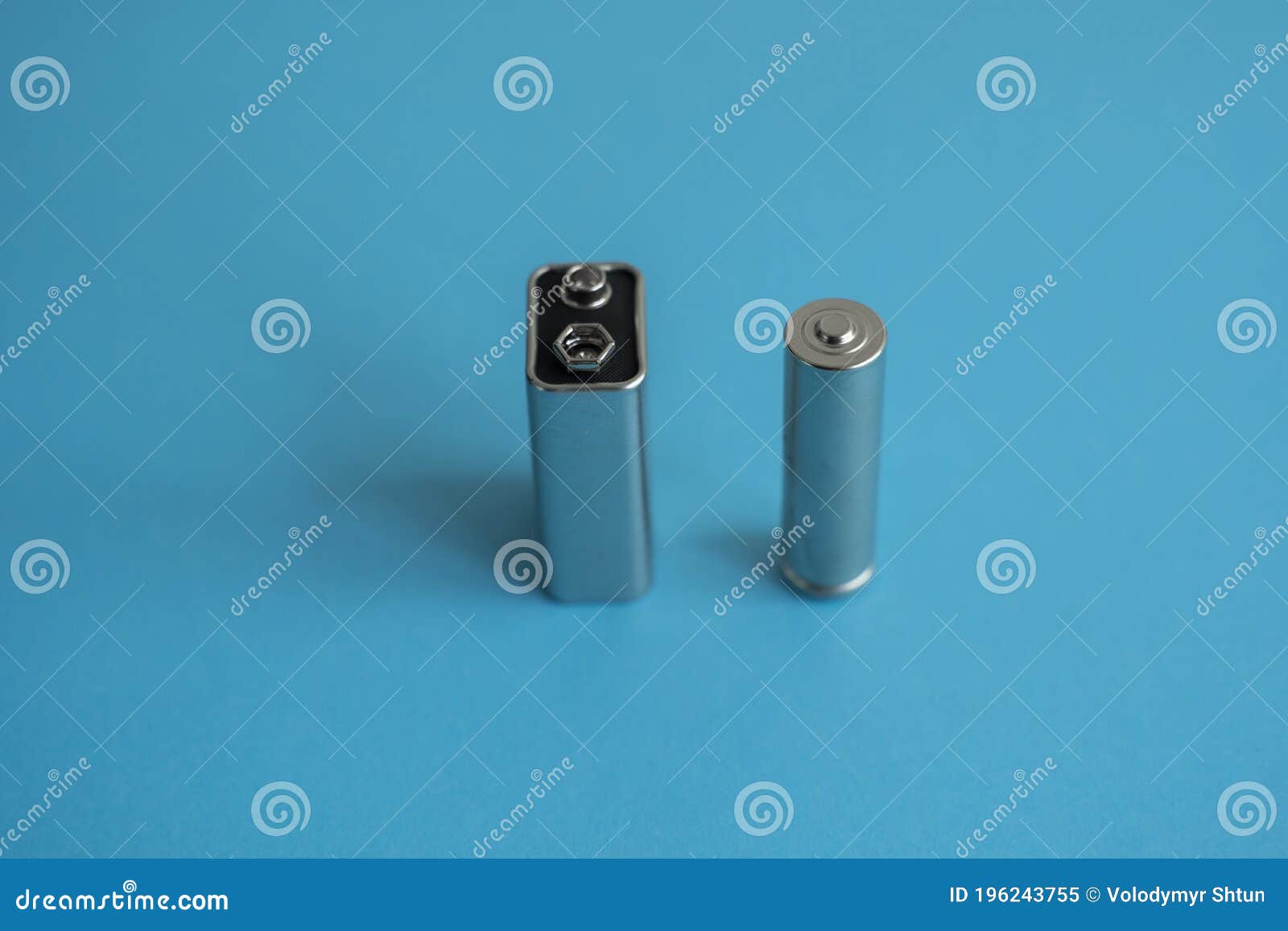 High Voltage Volt 9V Battery and Alkaline AA Battery on a Blue ...