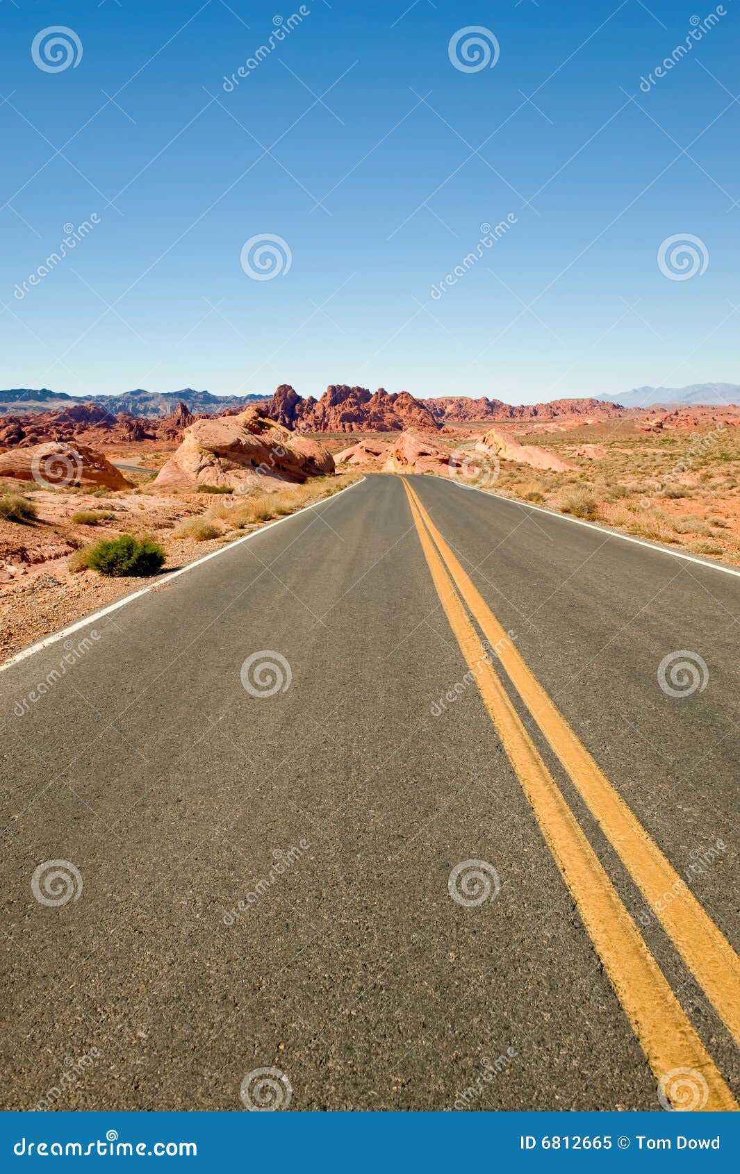 A Highway Receding To Perspective Toward A Mountain Range In A Desert ...