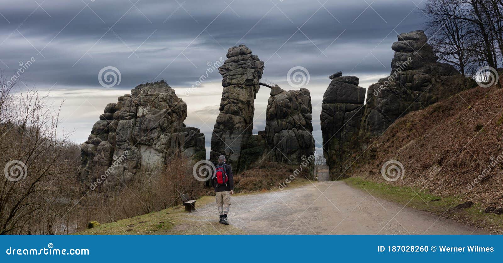 A Hiker with a Backpack Stands in Front of the Imposing Rocks of the ...