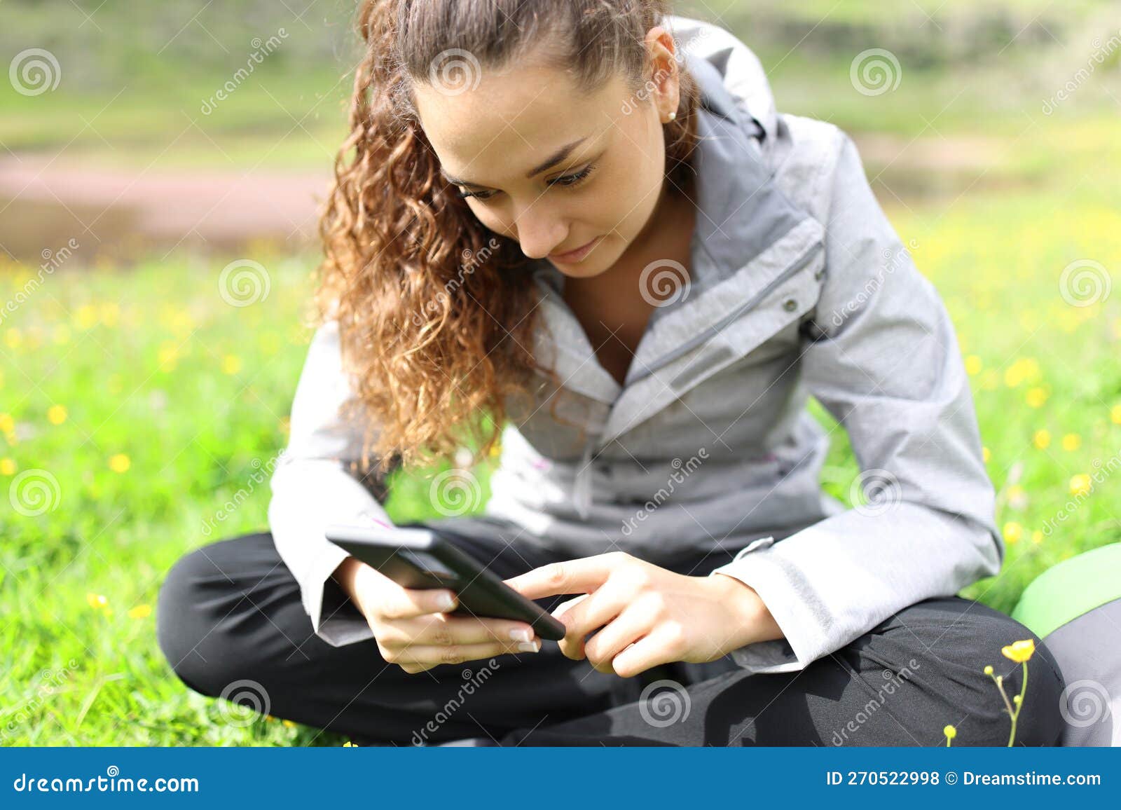 Hiker Checking Cell Phone Sitting on Grass Stock Photo - Image of ...