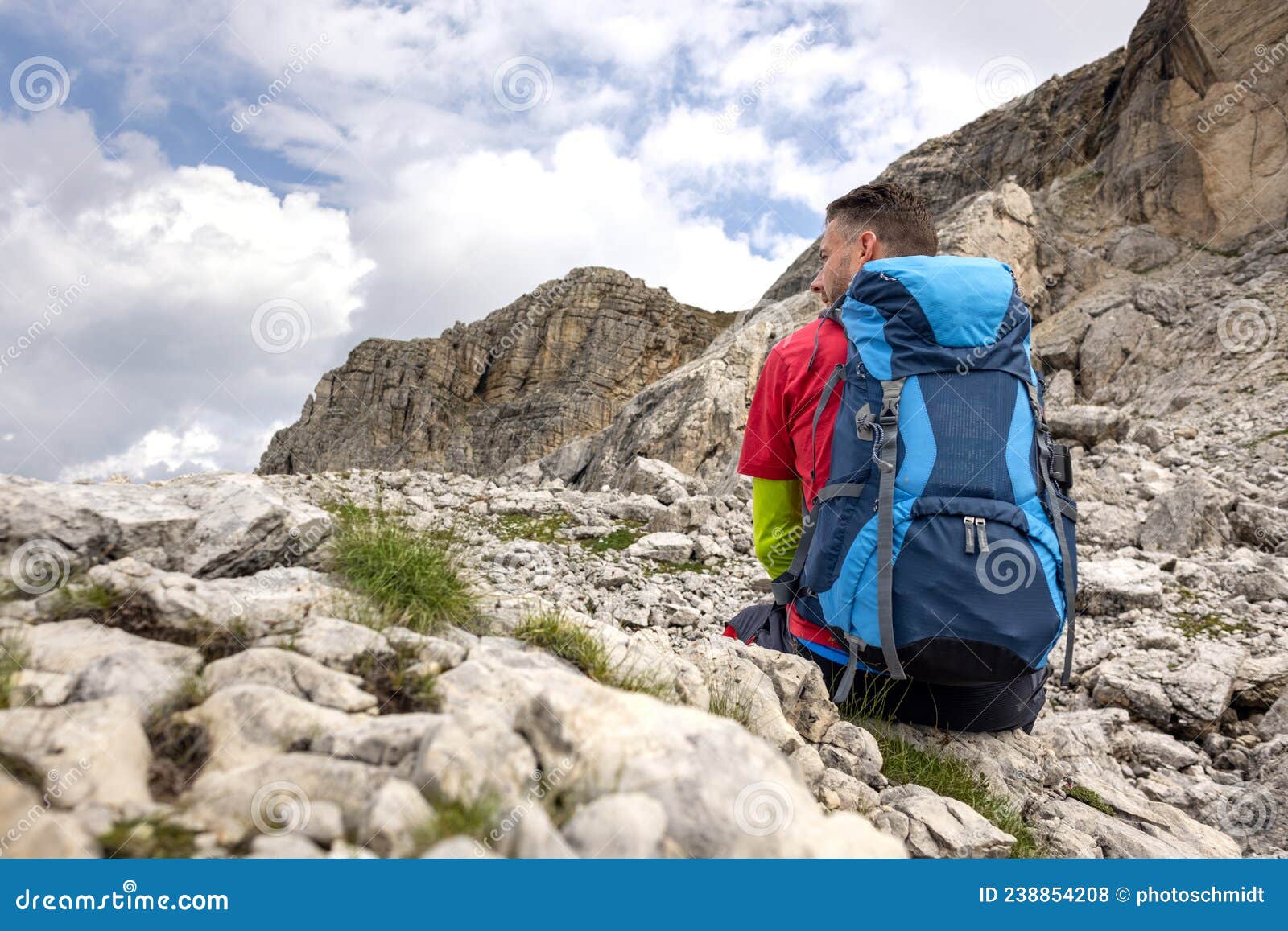 Hiker with a Large Backpack Sitting on Rocks on a Mountainside Stock ...