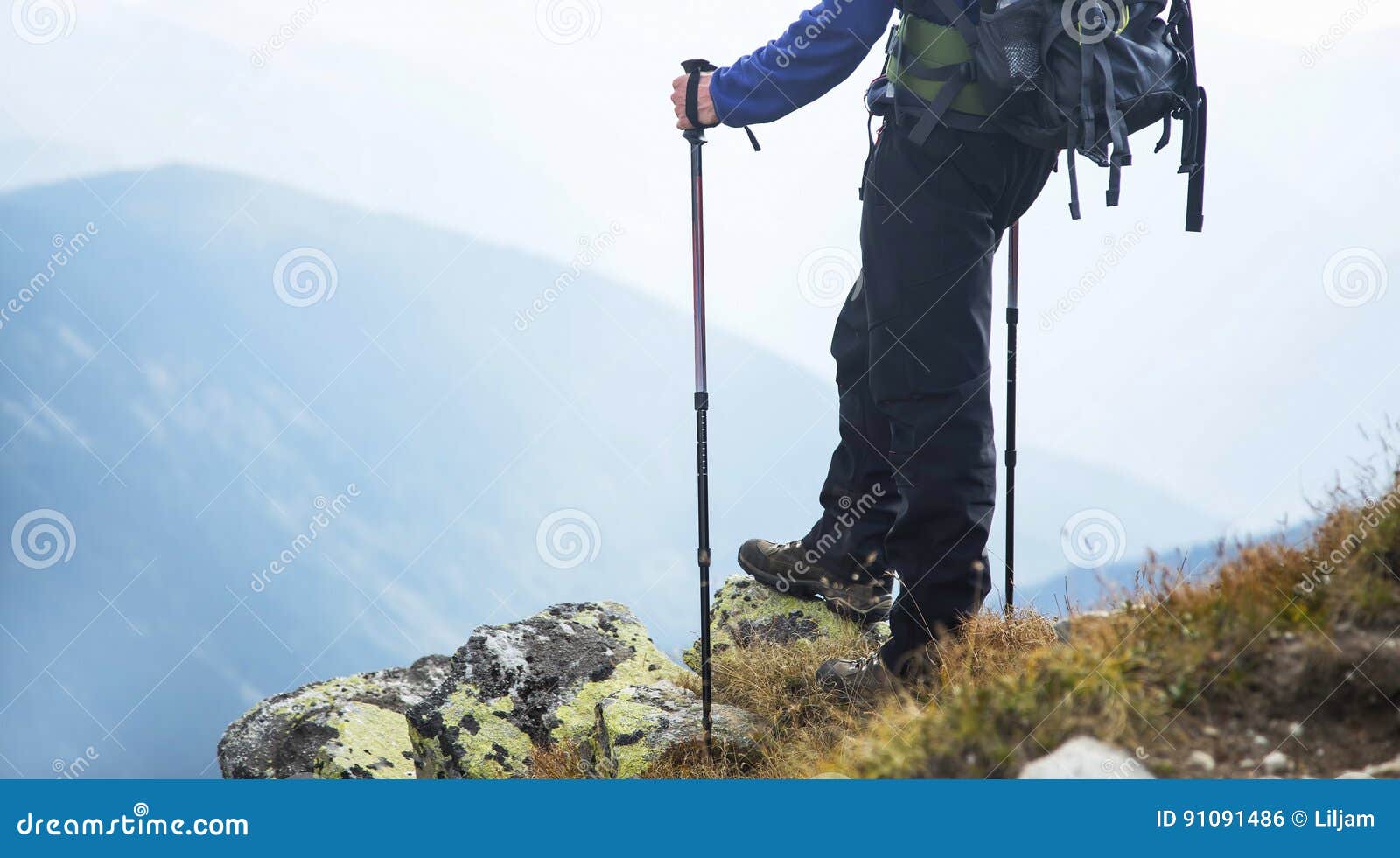 Hiker on a Rock on Top of Mountain with Trekking Sticks and Back Stock ...