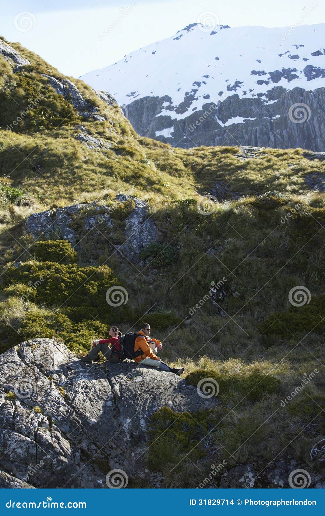 Hikers Sitting on Boulders in Mountain Valley Stock Photo - Image of ...