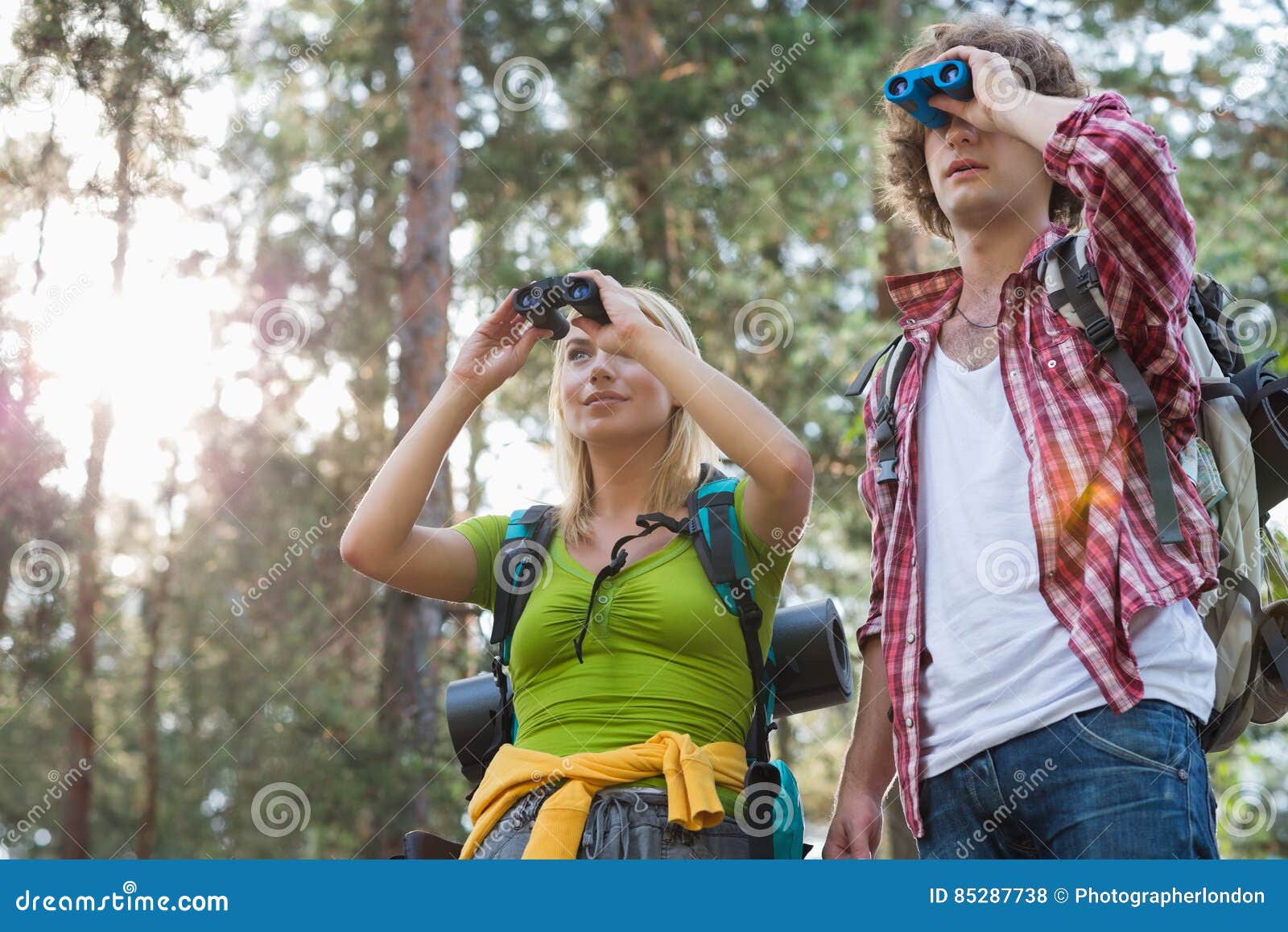 Hiking Couple Using Binoculars in Forest Stock Photo - Image of ...