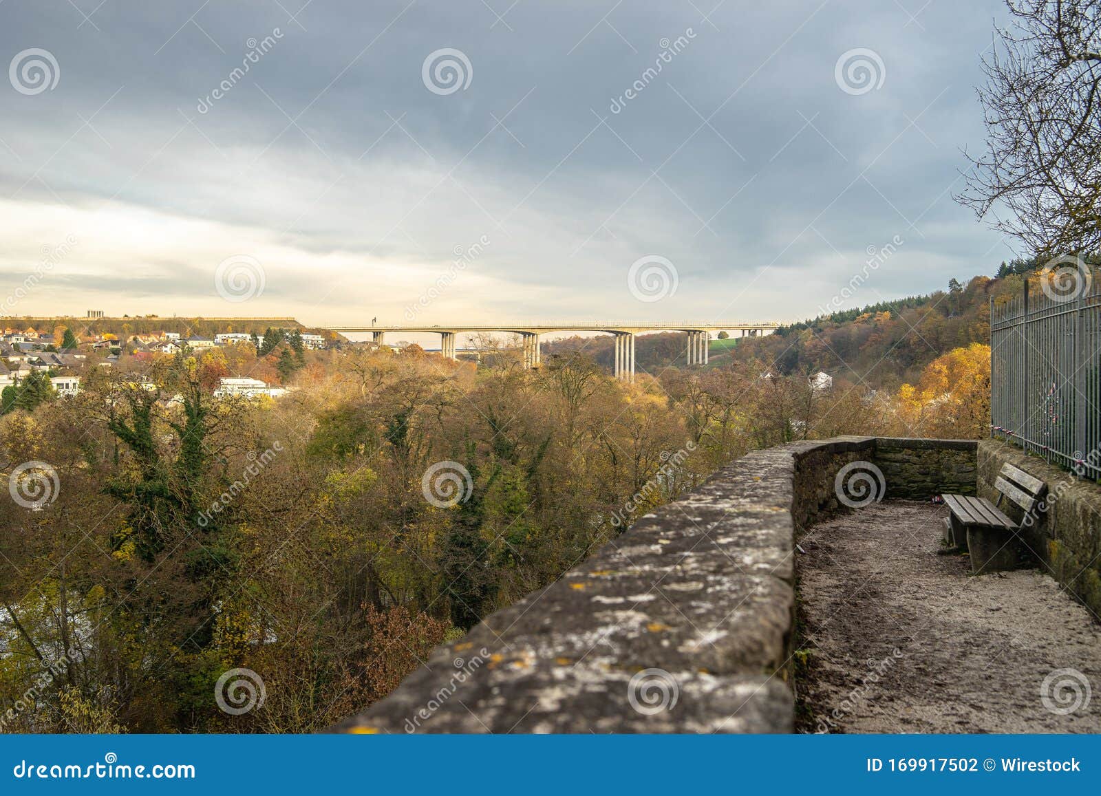 Hill Covered in Greenery with a Bridge and Buildings Under Sunlight on ...
