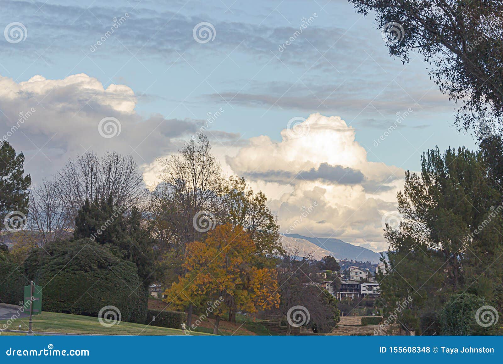 Hillside View of Homes with Gardens Mountains and Large Clouds Stock ...