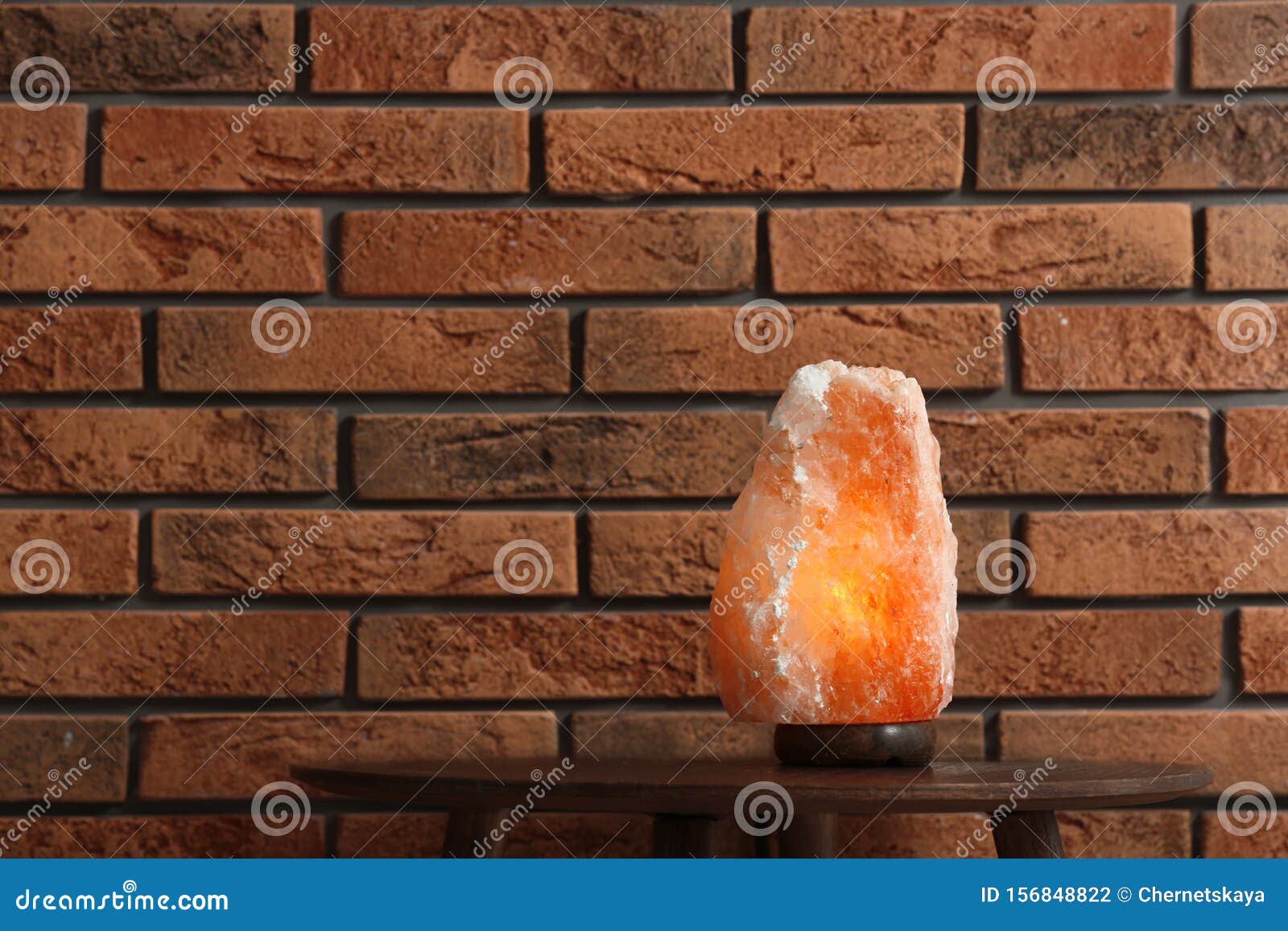 Himalayan Salt Lamp on Table Against Brick Wall Stock Photo - Image of ...