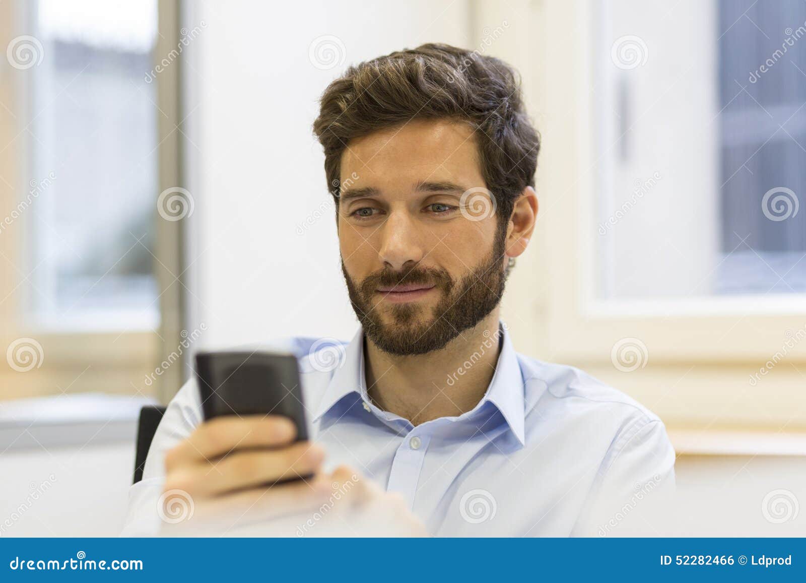 Hipster Man in Office. Typing Text Message on Mobile Phone Stock Photo ...