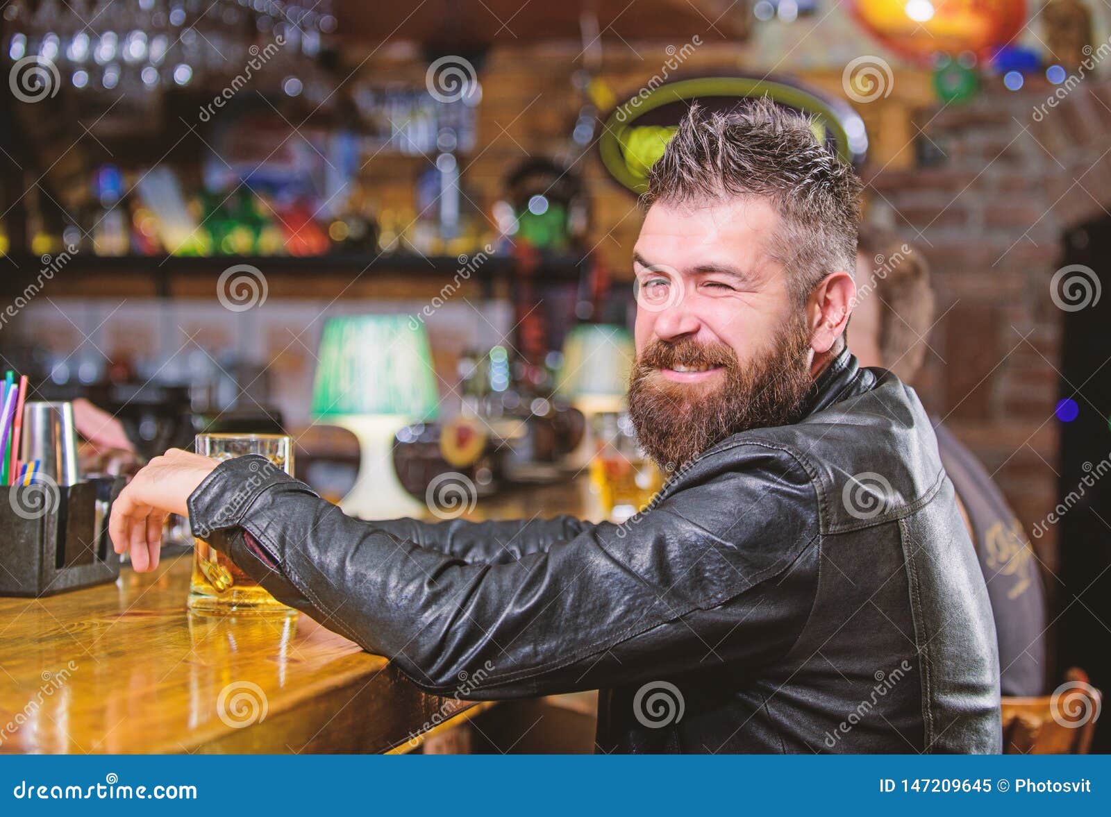 Hipster Relaxing at Bar with Beer. Brutal Hipster Bearded Man Sit at ... Hipster Relaxing at Bar with Beer. Brutal Hipster Bearded Man Sit at ...