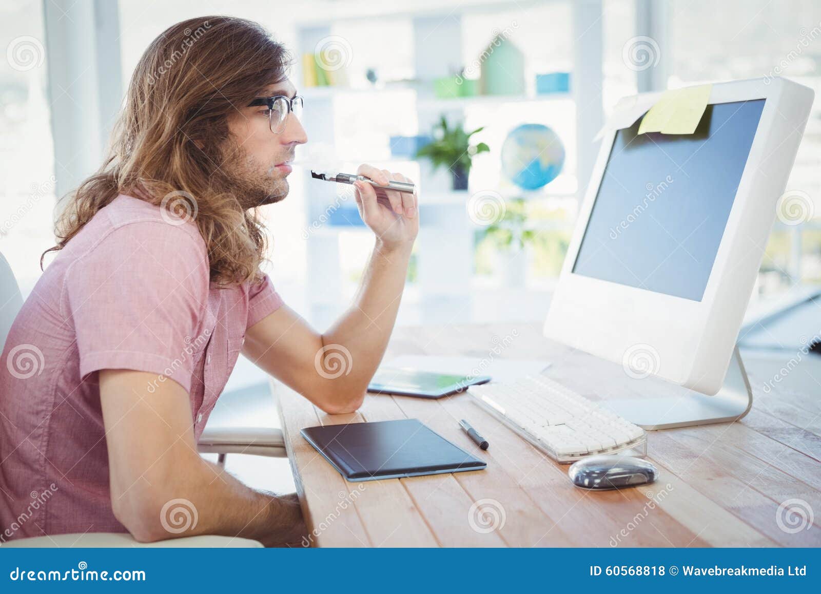 Hipster Smoking Electronic Cigarette at Computer Desk in Office Stock ...