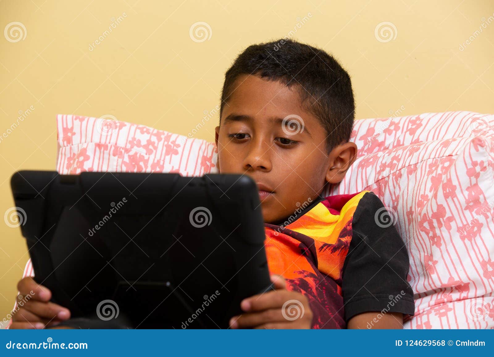 Hispanic Boy Using Tablet while in Bed Stock Photo - Image of child ...