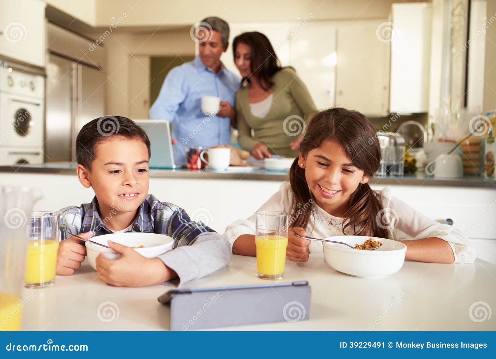 Hispanic Family Eating Breakfast Using Digital Devices Stock Image ...