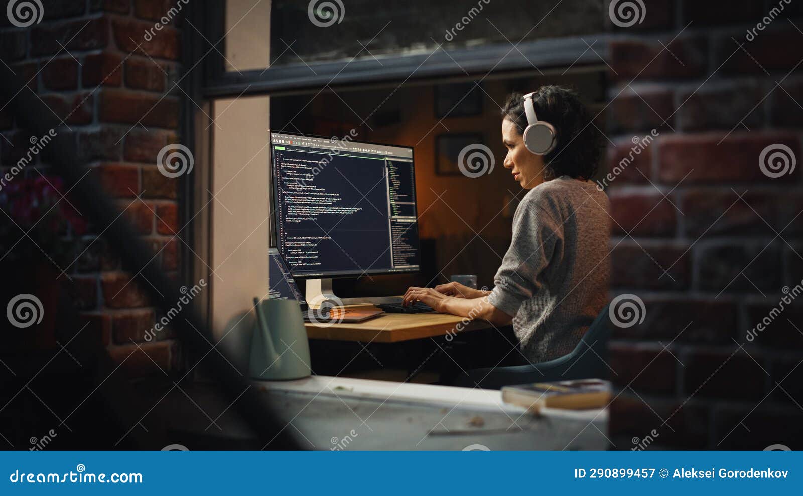 Hispanic Female Programmer in Headphones Listening Podcast and Working on Desktop Computer ...