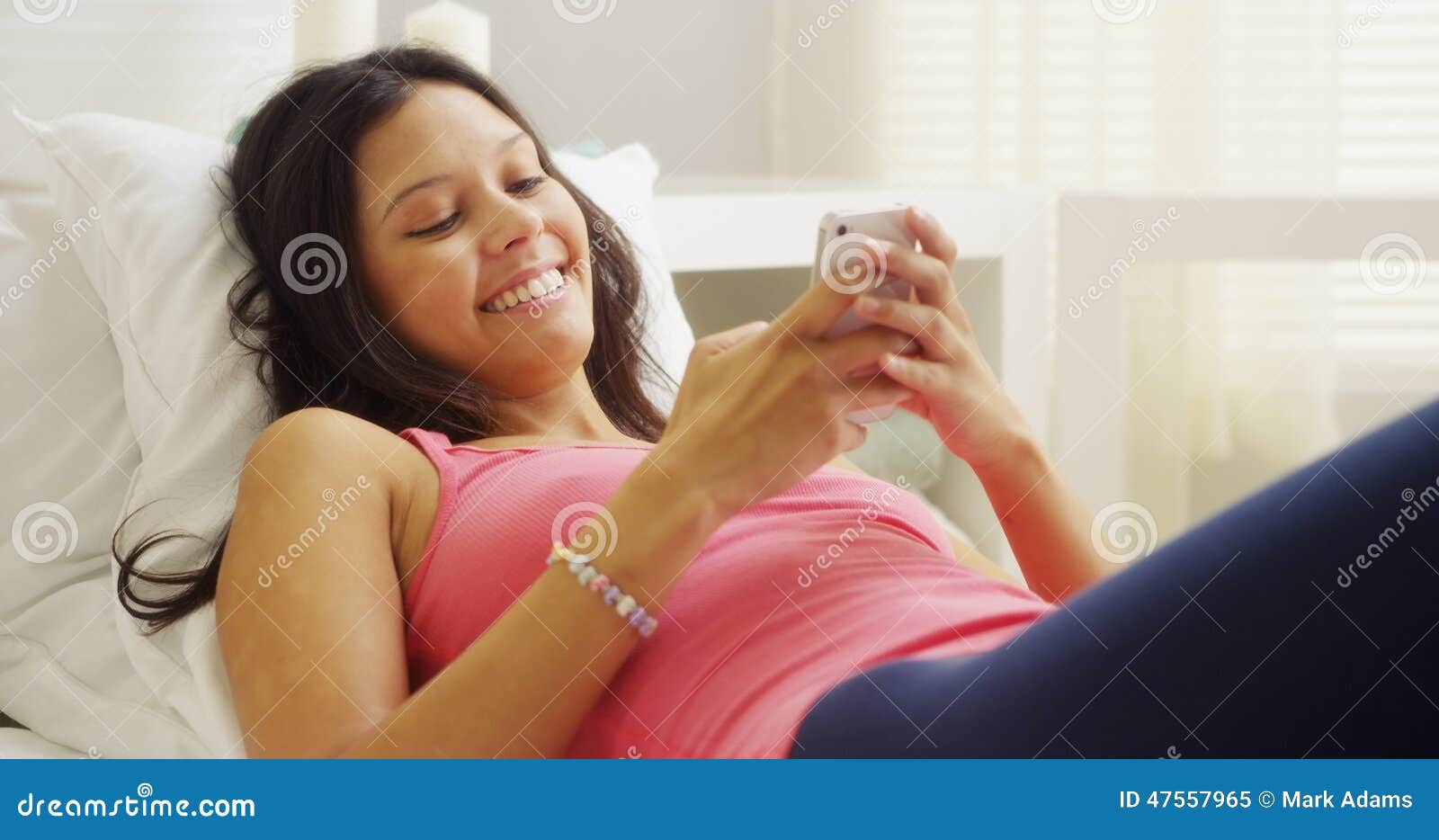 Hispanic Girl Laughing and Smiling while Texting Stock Image - Image of ...