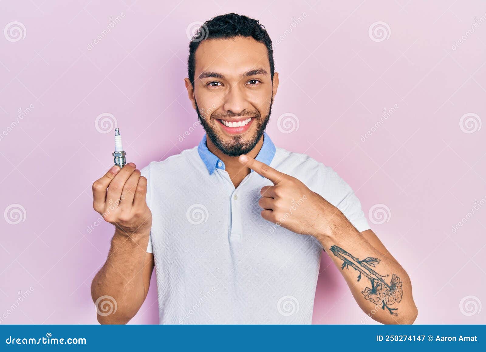 Hispanic Man with Beard Holding Spark Plug Smiling Happy Pointing with ...