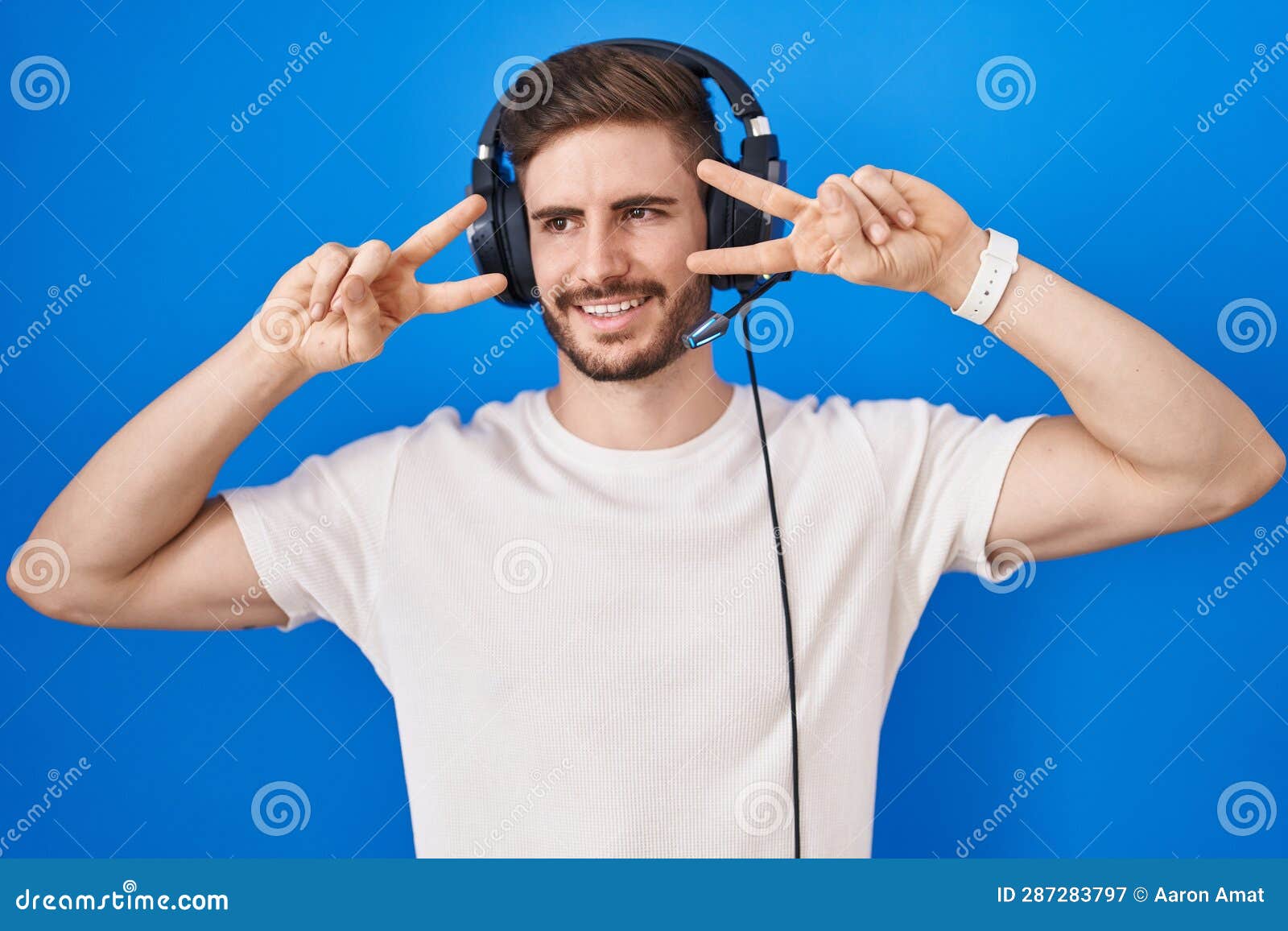 Hispanic Man With Beard Listening To Music Wearing Headphones Doing