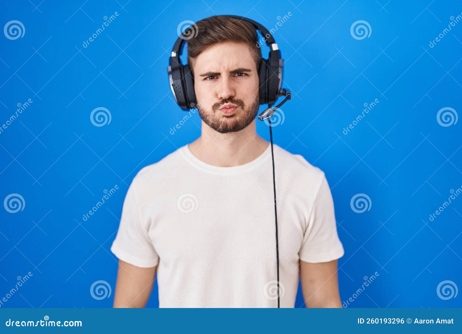 Hispanic Man With Beard Listening To Music Wearing Headphones Puffing