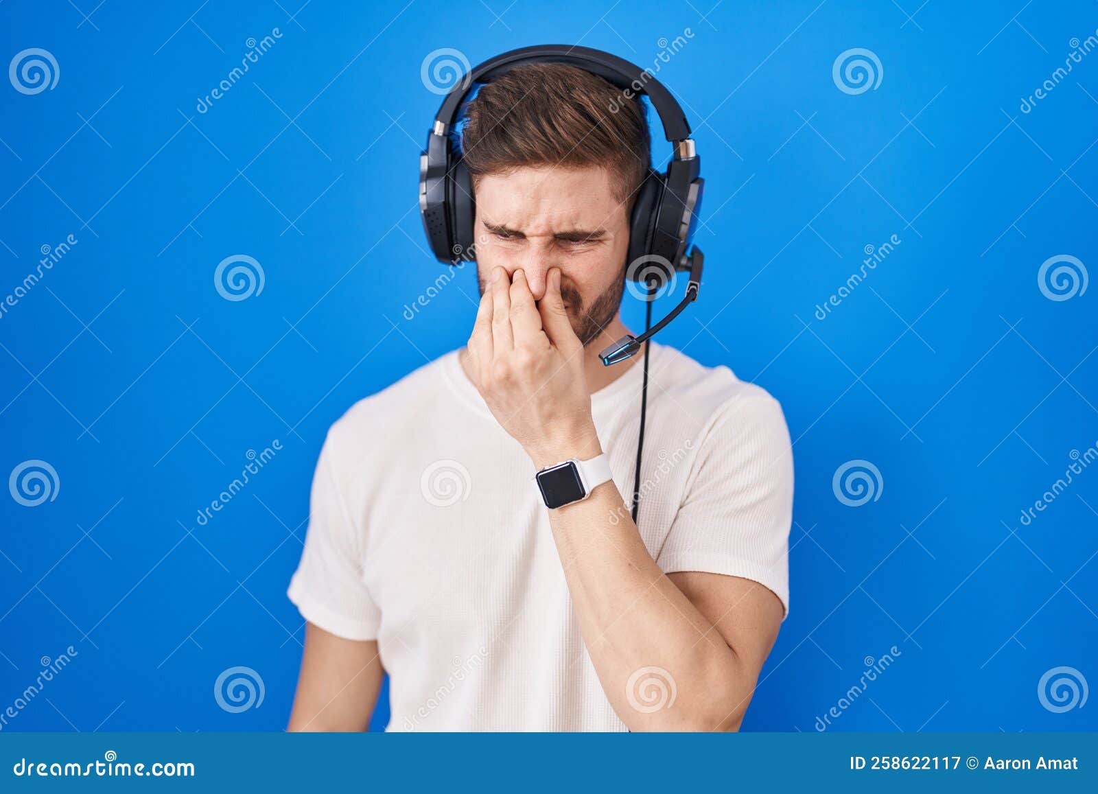 Hispanic Man With Beard Listening To Music Wearing Headphones Smelling
