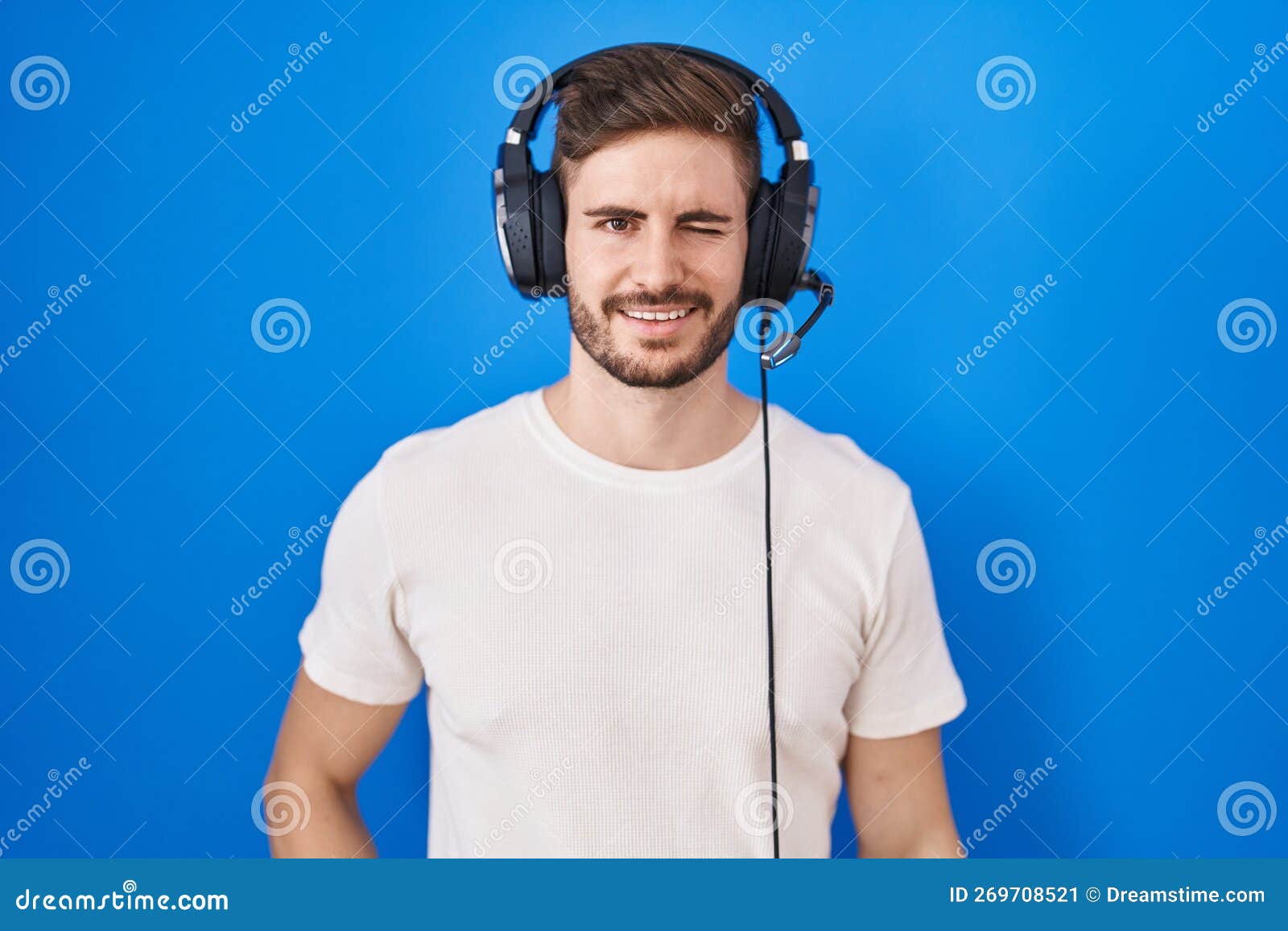 Hispanic Man With Beard Listening To Music Wearing Headphones Winking