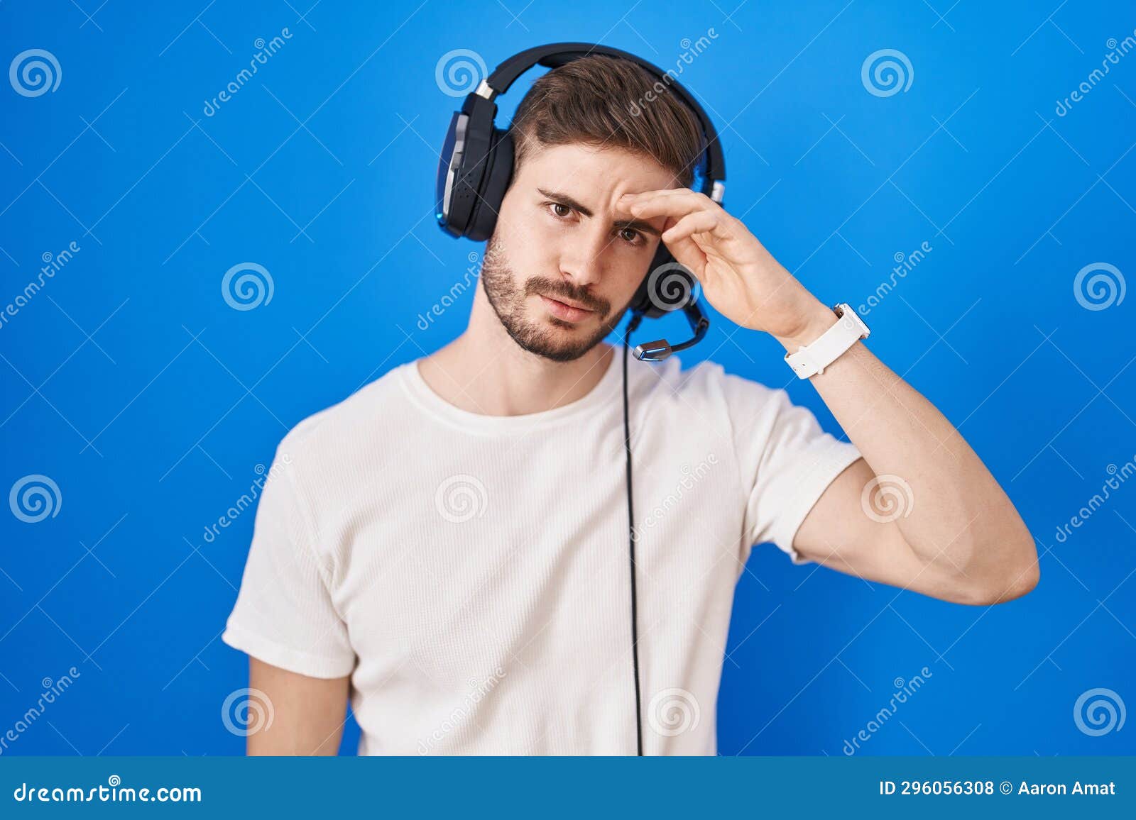 Hispanic Man With Beard Listening To Music Wearing Headphones Worried