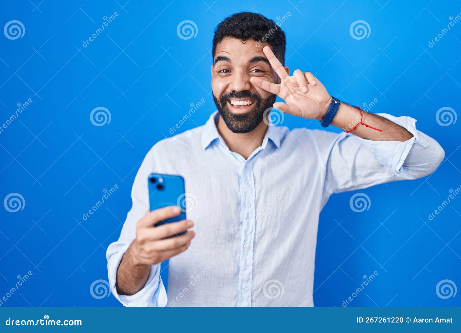Hispanic Man With Beard Using Smartphone Typing Message Doing Peace