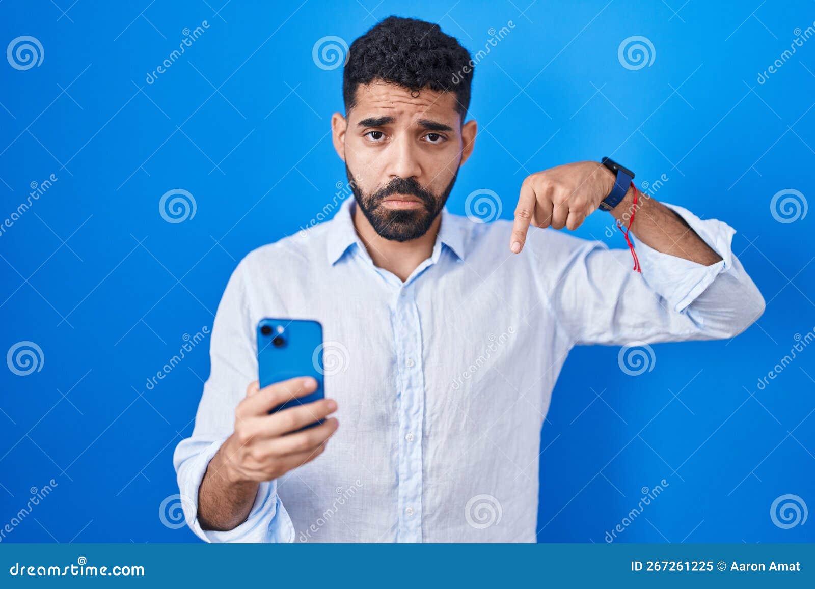 Hispanic Man With Beard Using Smartphone Typing Message Pointing Down