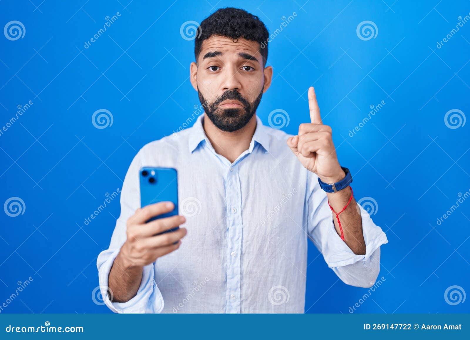 Hispanic Man With Beard Using Smartphone Typing Message Pointing Up