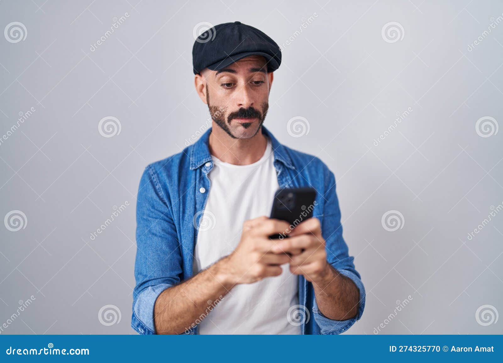 Hispanic Man With Beard Using Smartphone Typing Message Relaxed With
