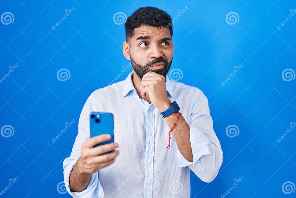Hispanic Man With Beard Using Smartphone Typing Message Thinking