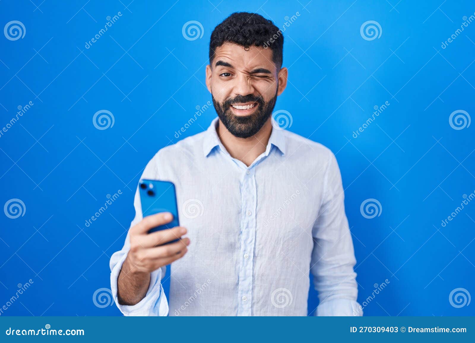 Hispanic Man With Beard Using Smartphone Typing Message Winking Looking