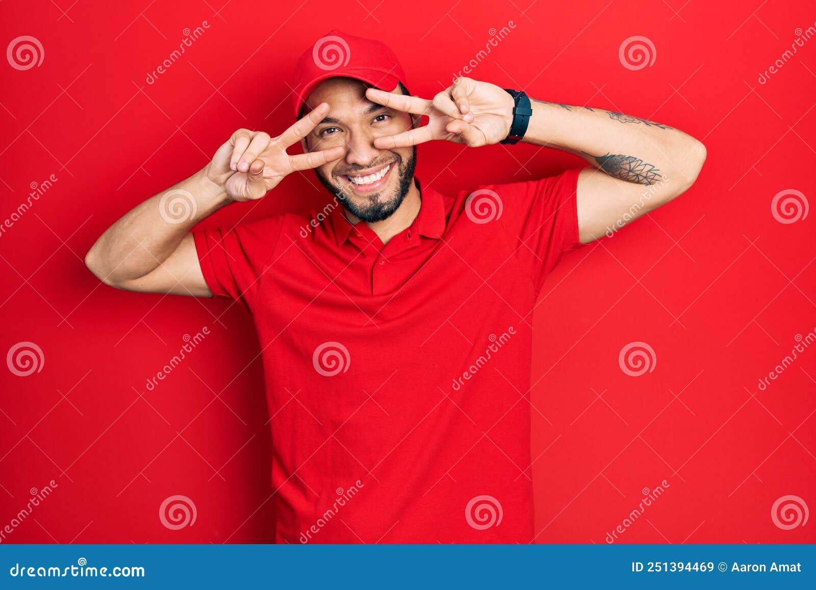 Hispanic Man With Beard Wearing Delivery Uniform And Cap Doing Peace