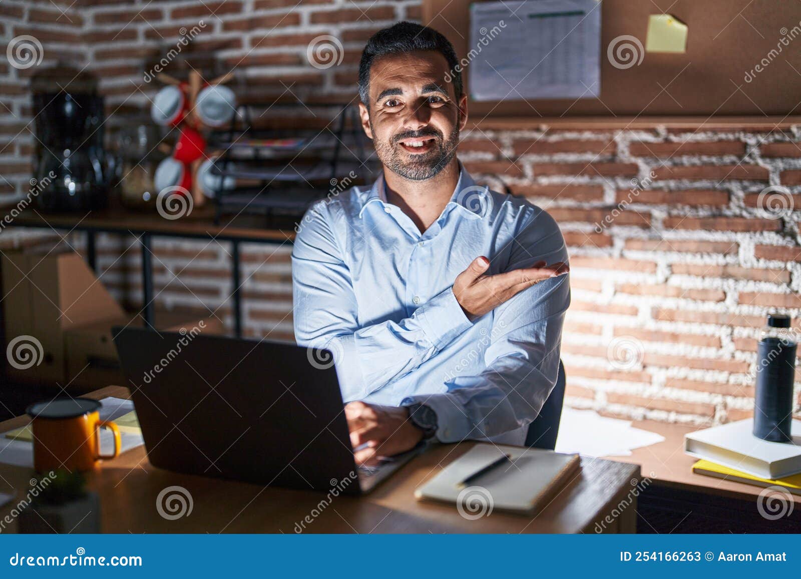 Hispanic Man with Beard Working at the Office at Night Pointing Aside ...