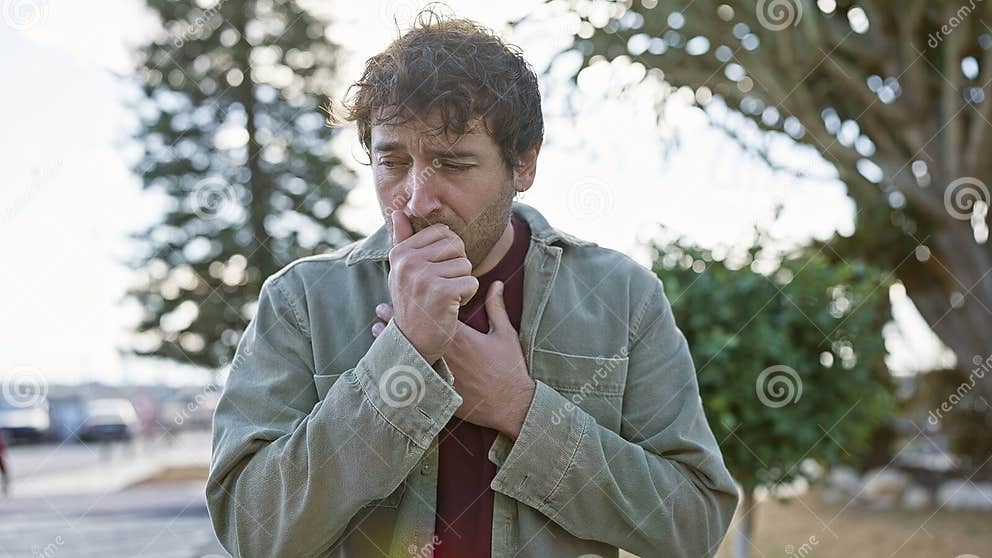 Hispanic Man Coughing Outdoors in a Park with Trees Stock Photo - Image ...