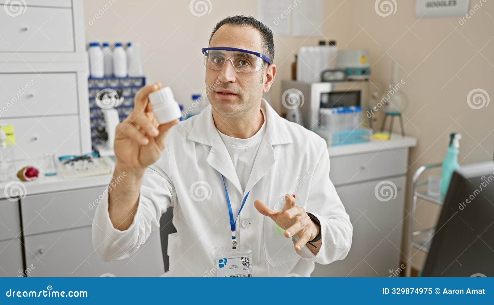 Hispanic Man in Lab Coat Holding Bottle Inside Laboratory Communicates ...