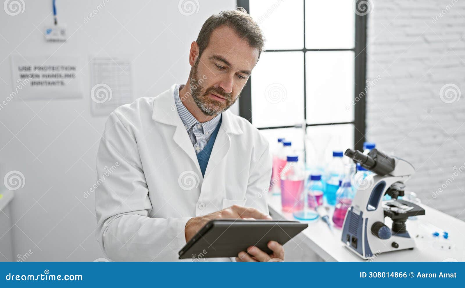 Hispanic Man in Lab Coat Uses Tablet in a Modern Laboratory with ...