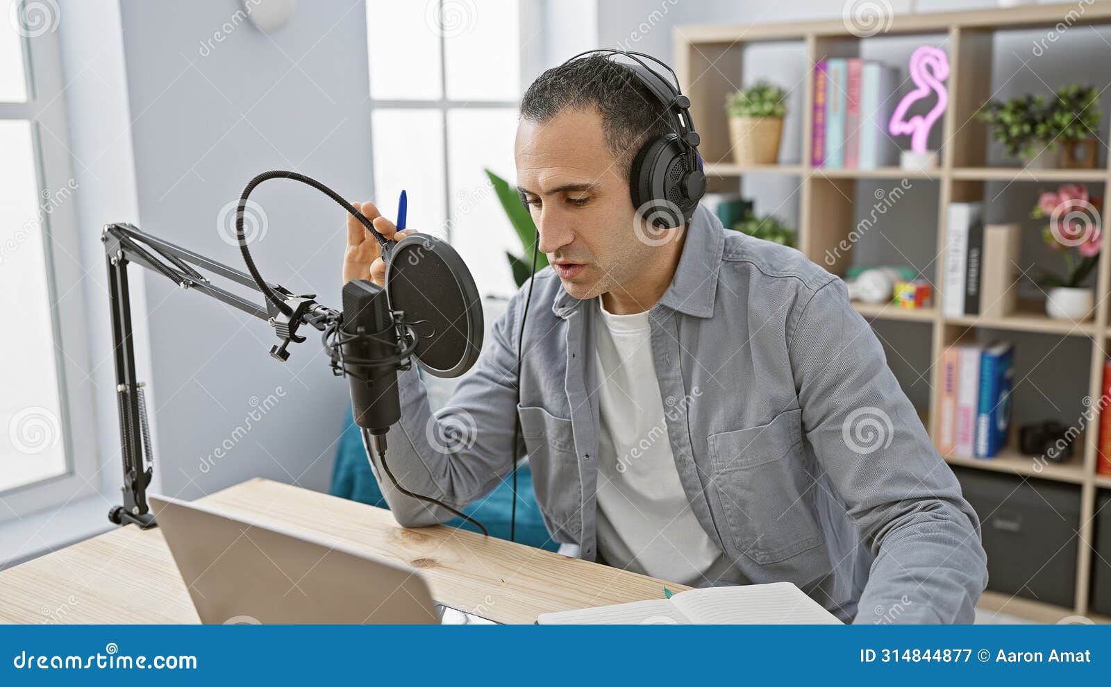 Hispanic Man Podcasting with Microphone and Headphones in a Home Studio ...