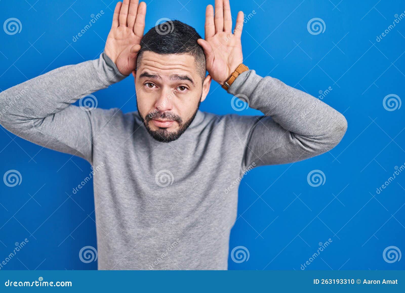 Hispanic Man Standing Over Blue Background Doing Bunny Ears Gesture ...