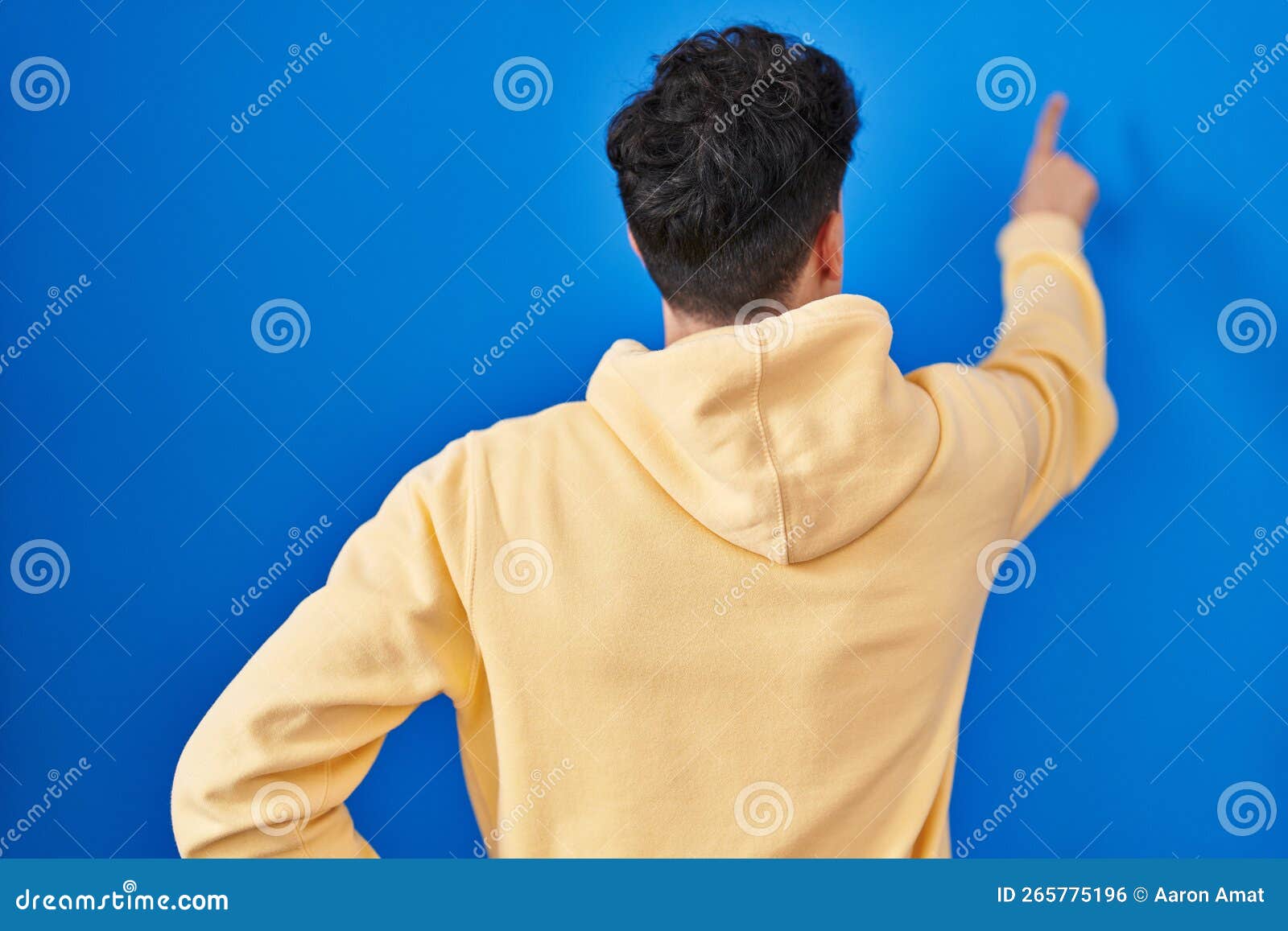 Hispanic Man Standing Over Blue Background Posing Backwards Pointing ...