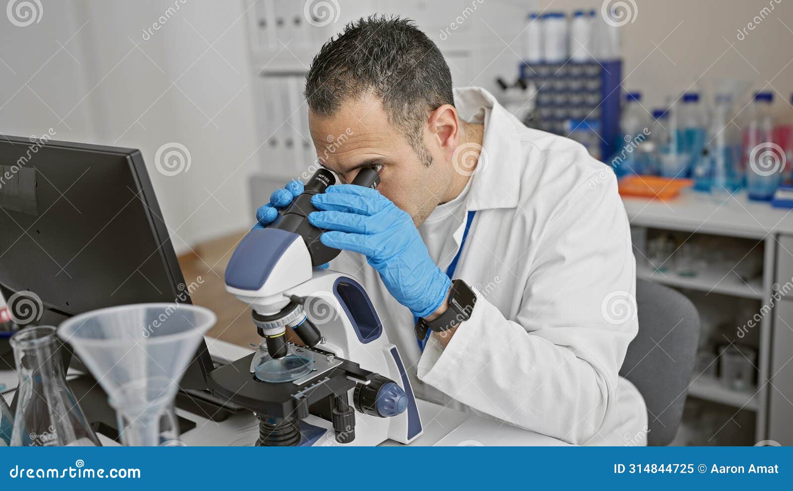 Hispanic Man Wearing Lab Coat Working with Microscope in Laboratory ...