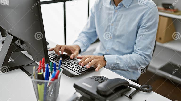 Hispanic Man Working at Computer in Modern Office Setting, Showcasing ...
